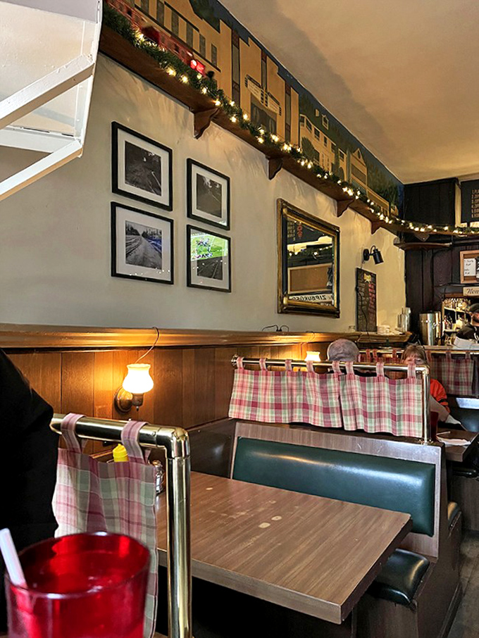 Red-checked curtains and vintage photographs on wood-paneled walls - not designed by an interior decorator, but by decades of genuine hospitality.