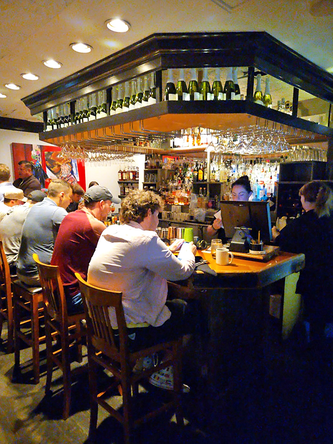 The bar at Midtown Cafe: where strangers become friends, and friends become regulars in the warm glow of perfectly arranged bottles.