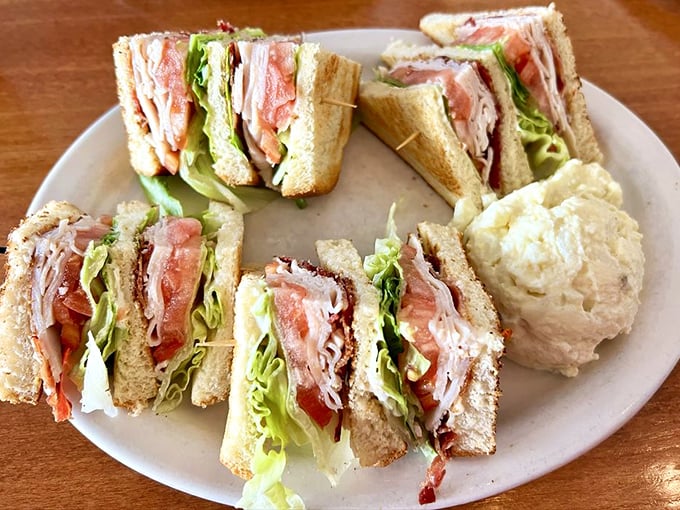 Club sandwich architecture that defies gravity. Those toothpicks aren't decorative—they're structural support for this tower of deliciousness.
