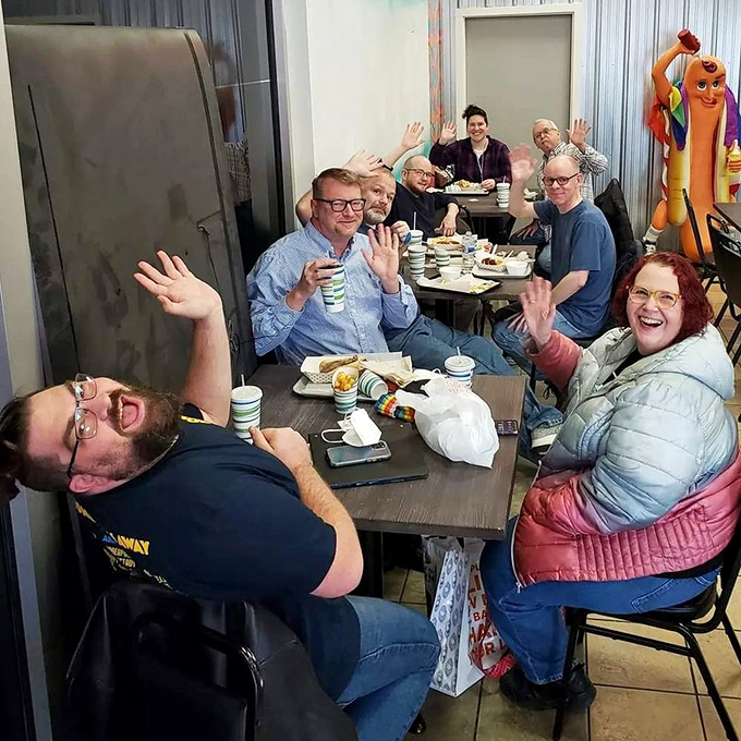 The universal language of good food brings people together, hands raised in celebration of the simple joy that is a perfectly crafted hot dog.
