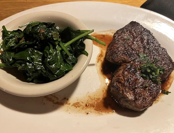 Filet mignon arrives tender enough to cut with a fork, accompanied by vibrant sautéed spinach.