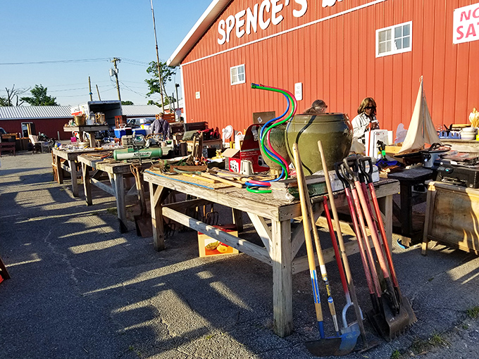 Garden tools stand at attention outside the barn—that green watering can has probably nurtured more successful gardens than most Instagram plant influencers.