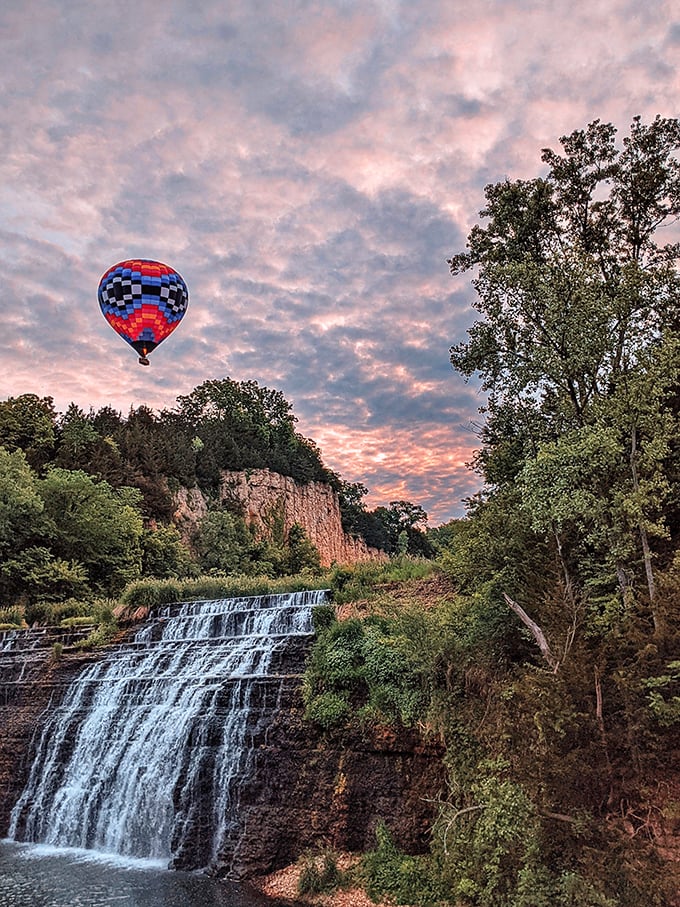 Hot air balloon meets cool falling water at sunset – a scene so perfectly composed it looks like Illinois hired a Hollywood set designer.