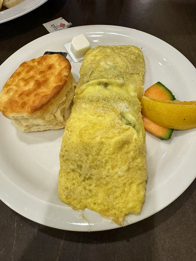 An omelet that defies physics—somehow fluffy yet substantial, paired with a biscuit that's worth the carbs and then some.
