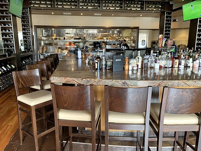 Bar seating offers front-row views of culinary action while maintaining intimate conversation-friendly atmosphere throughout.