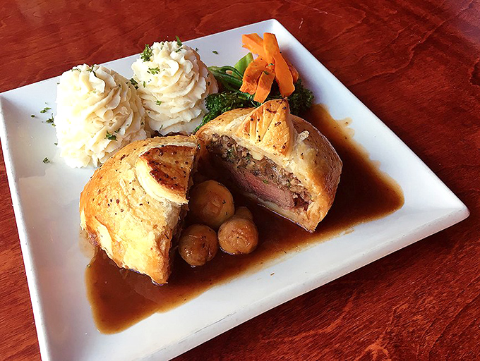 Beef Wellington cut open to reveal its rosy secret – a dish so perfectly executed it would make Gordon Ramsay drop his famous scowl for a smile.