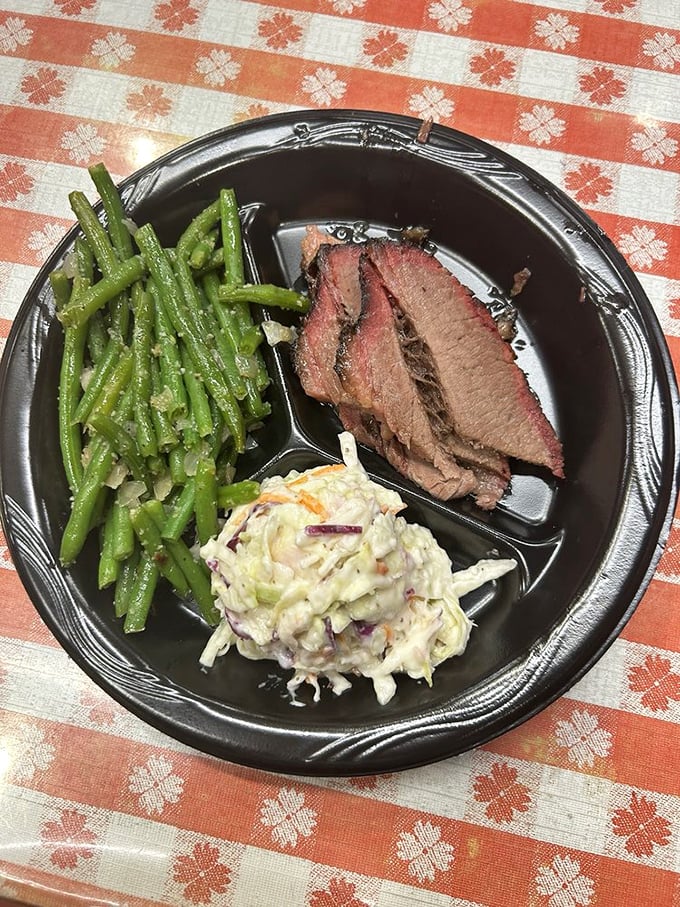 A perfect trinity: brisket with its smoky halo, green beans for virtue, and coleslaw for crunch—the holy balance of a proper Texas plate.