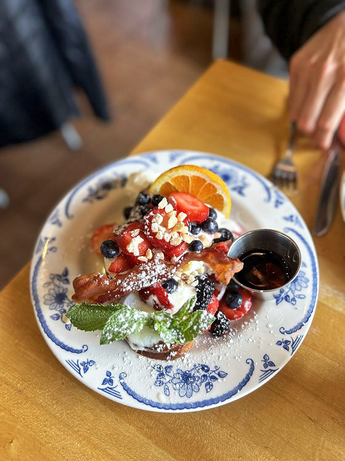 French toast elevated to an art form – where berries, powdered sugar, and maple syrup create a breakfast symphony.