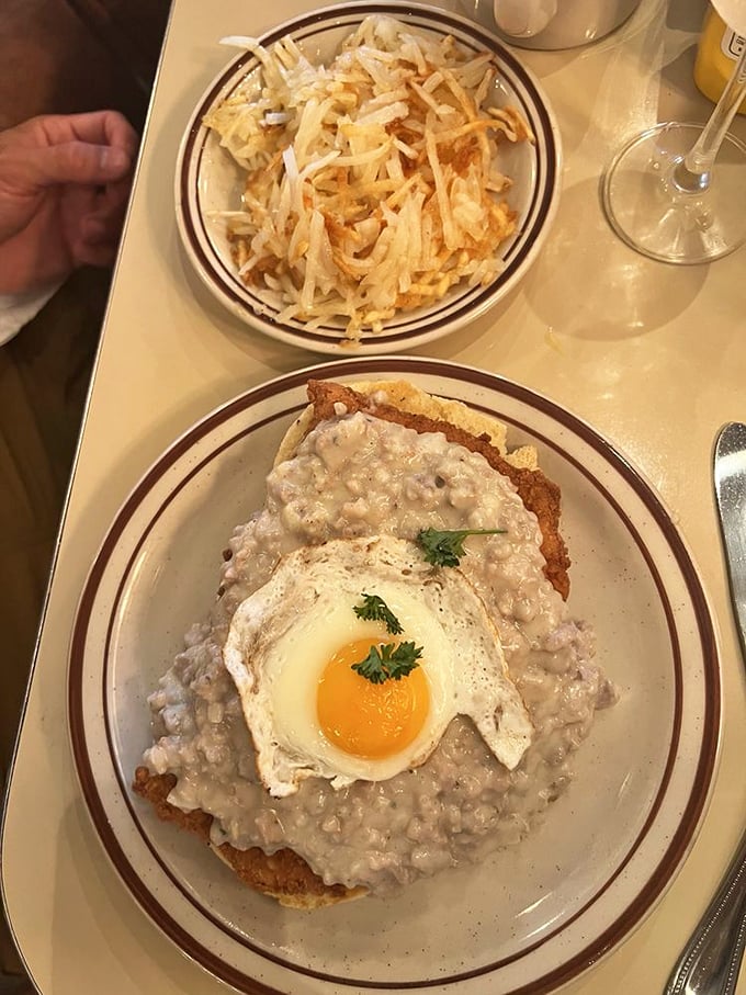 Biscuits and gravy topped with a sunny-side-up egg – the breakfast equivalent of a warm hug. That crispy hash brown side isn't just a garnish; it's an essential supporting character.