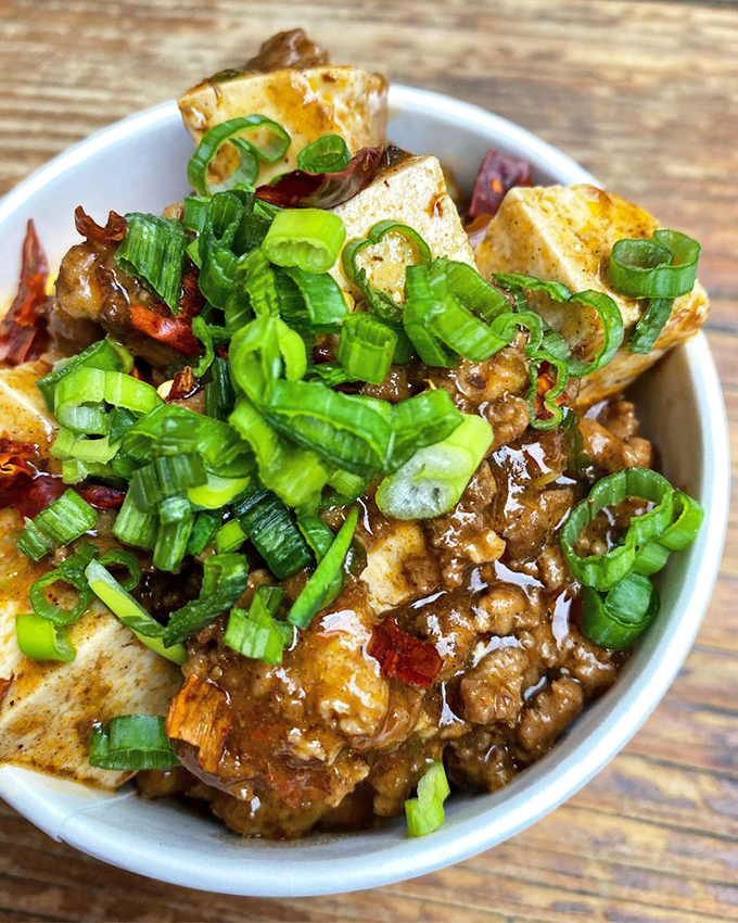 Tofu that's having an identity crisis in the best possible way. Those green onions aren't garnish—they're exclamation points.