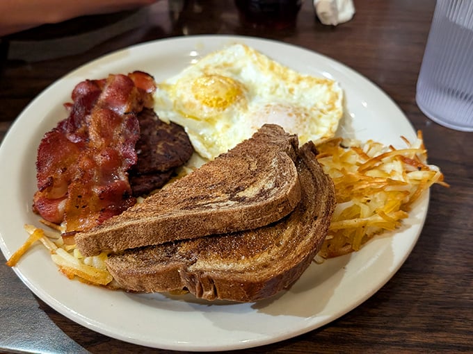 Breakfast fundamentals executed with precision—crispy bacon, perfectly fried egg, golden toast, and those hashbrowns that somehow improve everything they touch.
