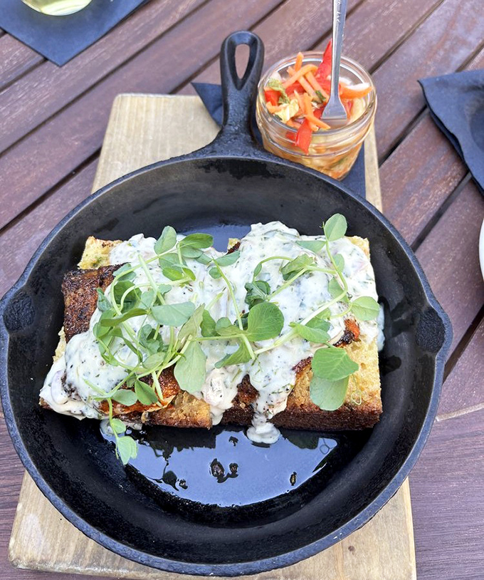 This cornbread stack topped with creamy sauce and microgreens proves that sometimes the best supporting actors steal the show from the sandwich stars.