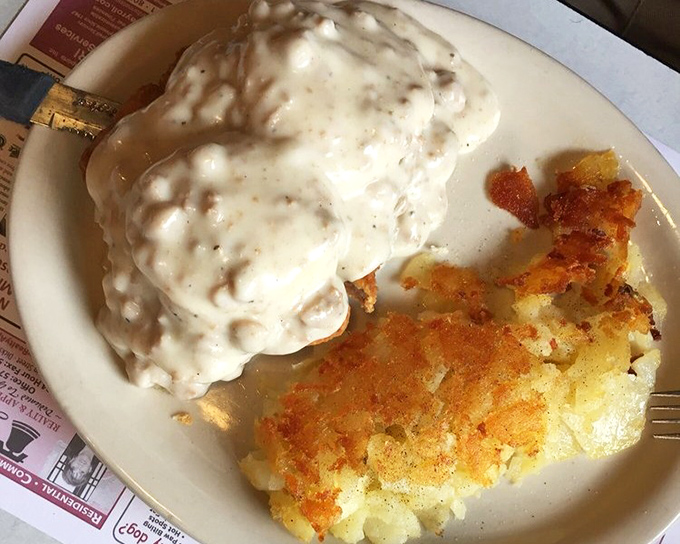 This isn't just country fried steak—it's a gravy-laden masterpiece that renders conversation impossible except for appreciative mumbling. Those hash browns deserve their own fan club. 