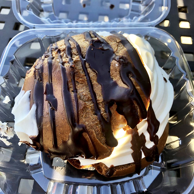 This cream puff with chocolate drizzle isn't just dessert, it's architecture. A structurally sound dome of bliss that belongs in a museum.