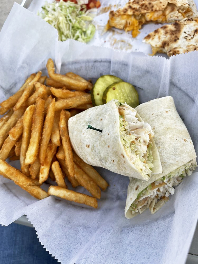 The fish taco wrap—ocean meets garden, all tucked neatly into a tortilla. Those perfectly golden fries are the supporting actors who consistently steal the scene.