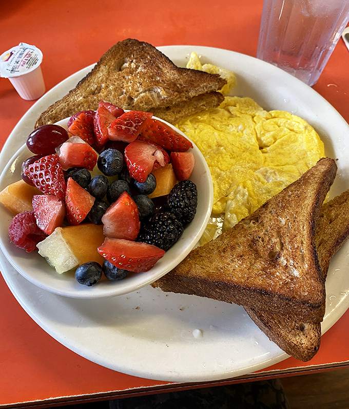 A breakfast that understands balance – golden French toast, fluffy eggs, and fruit that makes you feel virtuous about your indulgence.