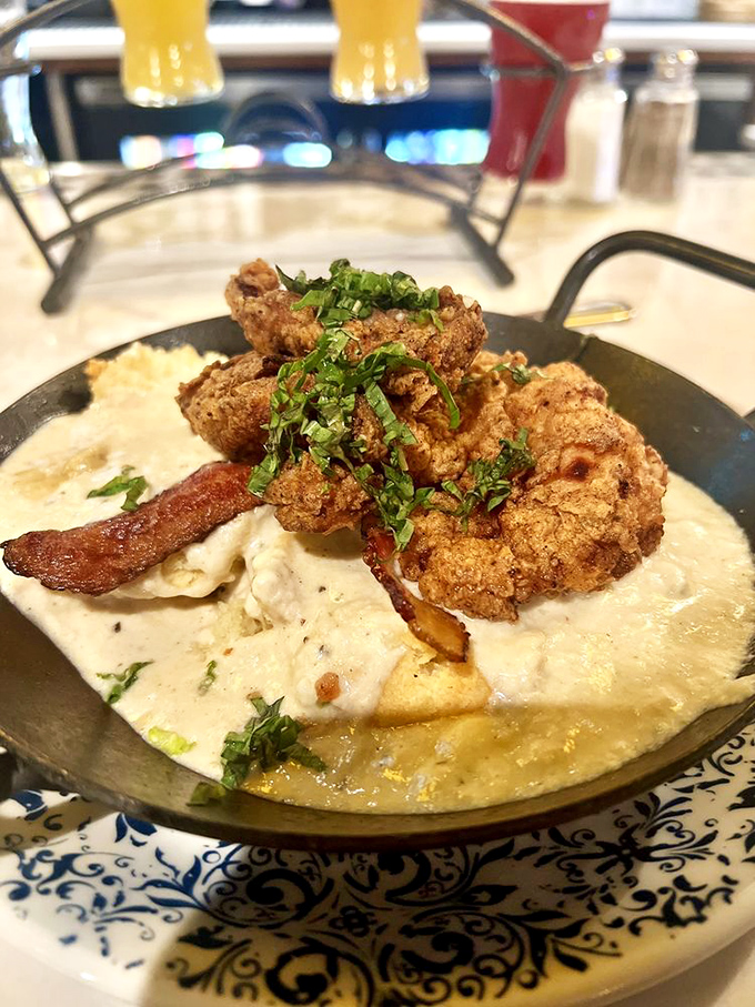 Southern comfort reimagined—crispy fried chicken nestled on creamy grits like it's found its soulmate after years of searching.