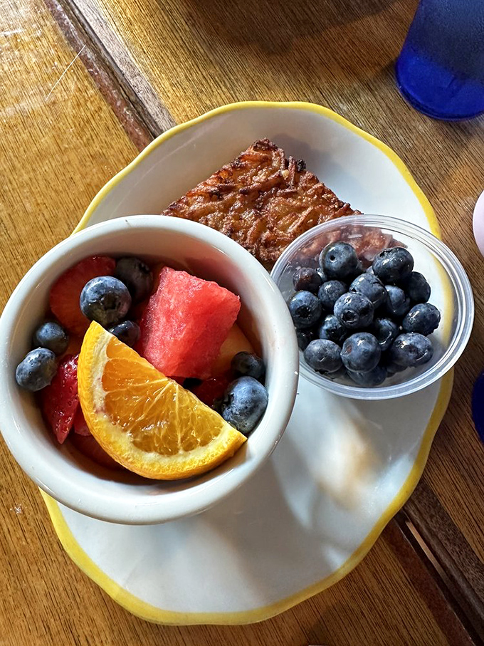 Fresh fruit and a potato latke sharing a plate—the breakfast equivalent of having both an angel and devil on your shoulders.