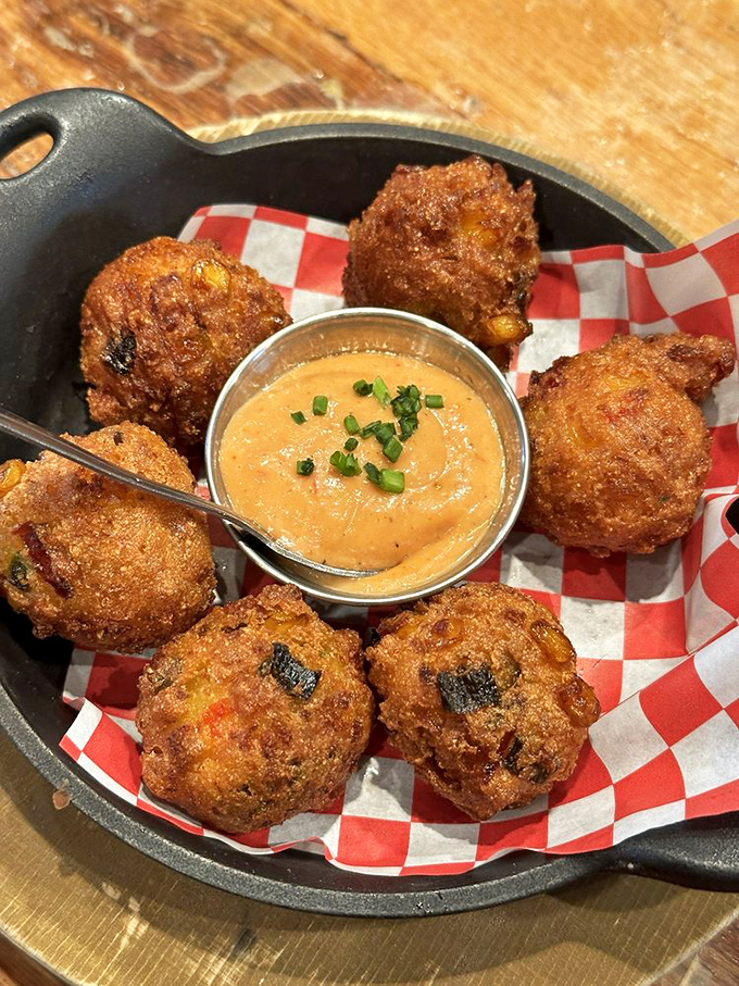 Hush puppies that actually make you want to shout—crispy, golden orbs of cornmeal joy served with a dipping sauce worth fighting over.