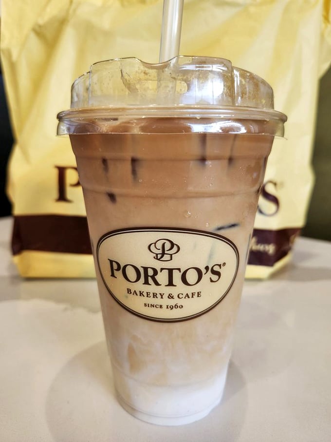 This iced latte isn't just a coffee—it's summer vacation in a cup, complete with the Porto's logo as your passport to caffeinated bliss.