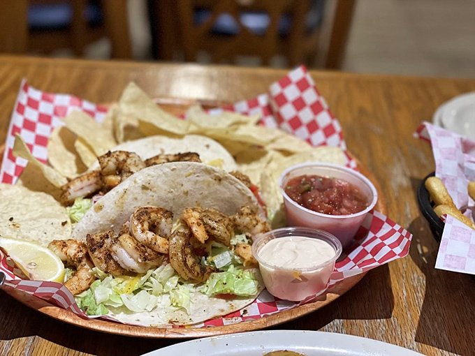 Shrimp tacos served with a side of tortilla chips and dipping sauces. A handheld vacation that requires no passport—just napkins