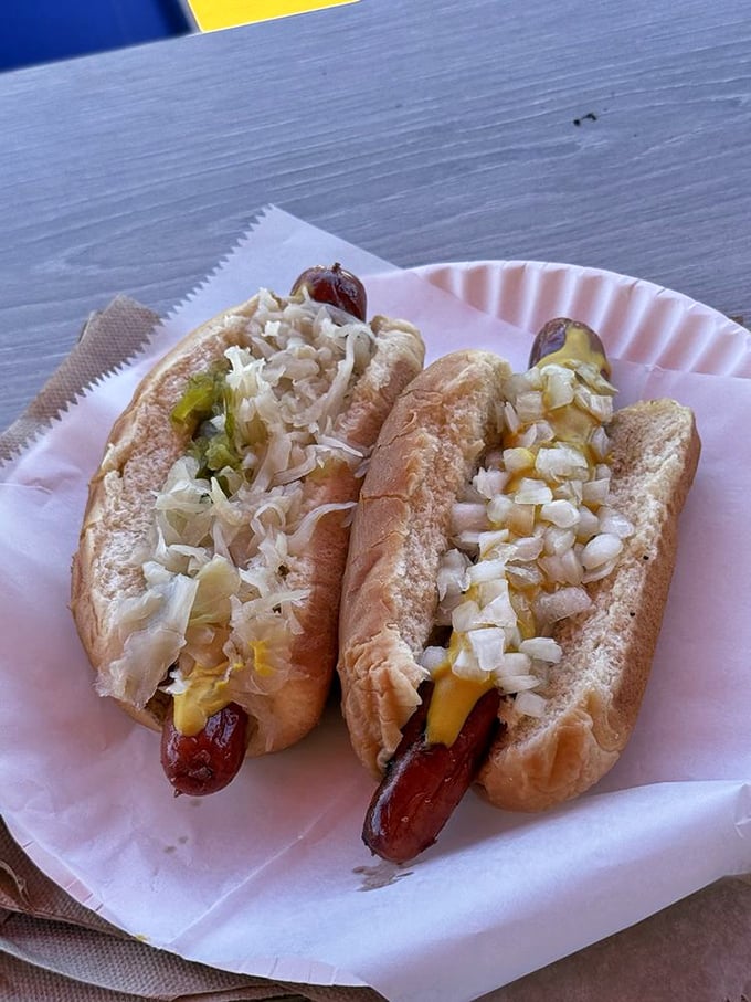 Two hot dogs dressed to impress with the classic trio of kraut, mustard, and relish—proof that sometimes tradition knows best.