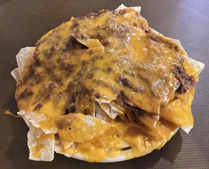 Nachos that require a strategy to eat—each chip a potential vehicle for maximum cheese-to-chili ratio perfection.