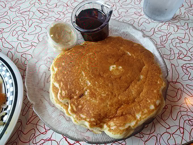 A pancake so perfectly golden it deserves its own spotlight—the supporting actors of butter and syrup wait patiently in the wings.