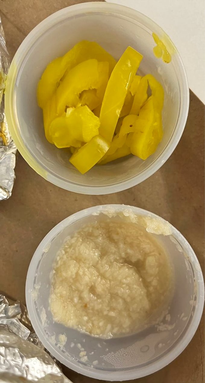 The condiment containers might be humble, but those banana peppers and horseradish are flavor bombs waiting to elevate your sandwich experience.