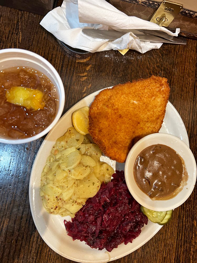 This schnitzel plate is a geography lesson on a dish – golden breaded cutlet bordering vibrant red cabbage and creamy potato salad.
