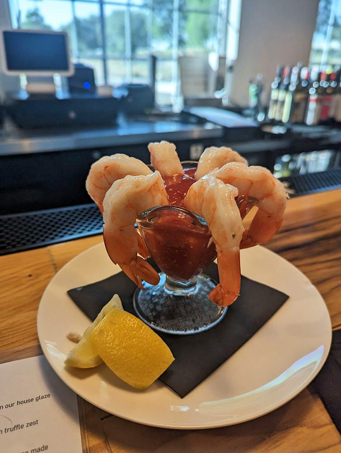 Shrimp cocktail reimagined as an elegant crown around a glass of tangy sauce—seafood that knows it deserves the royal treatment.