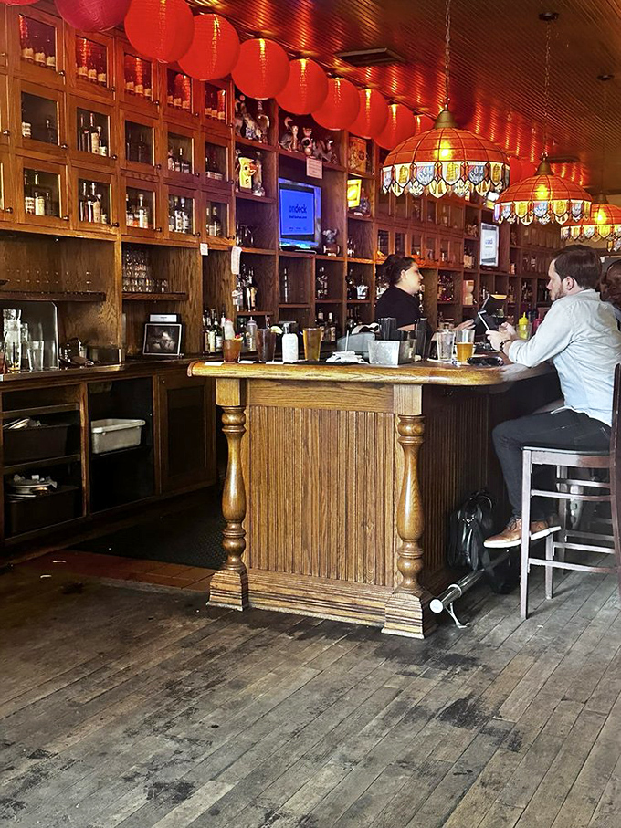 Behind every great bar is a team that knows the difference between serving drinks and creating memories. This wooden altar to libations isn't just functional – it's sacred.
