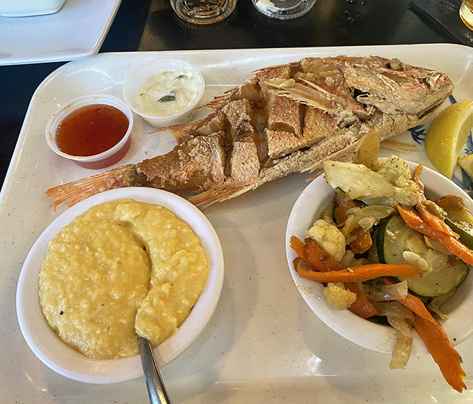A whole fried fish presented with the confidence of a chef who knows exactly what you need before you do. Those sides aren't afterthoughts—they're co-stars.