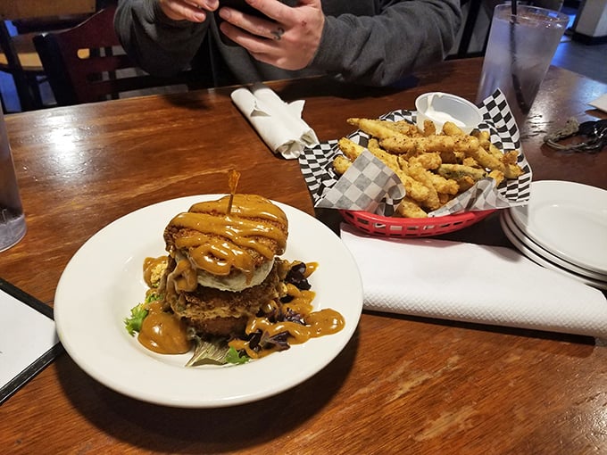 This burger doesn't just arrive—it makes an entrance. The sauce cascading down the sides promises a gloriously messy eating experience.