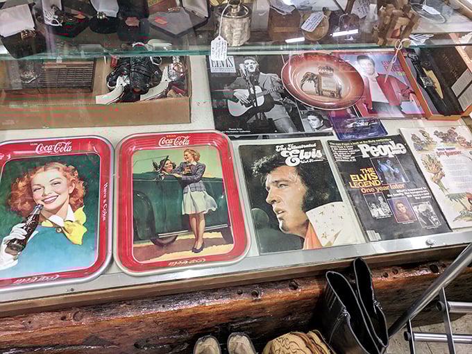 Elvis hasn't left the building—he's just moved to this display case. Vintage Coca-Cola trays share space with the King's memorabilia.