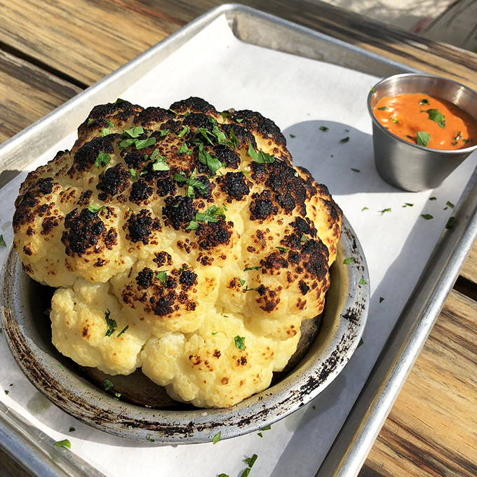 The whole roasted cauliflower arrives looking like it could be displayed in an art gallery, but tastes like it should be served in heaven. Vegetable skeptics, prepare to be converted.