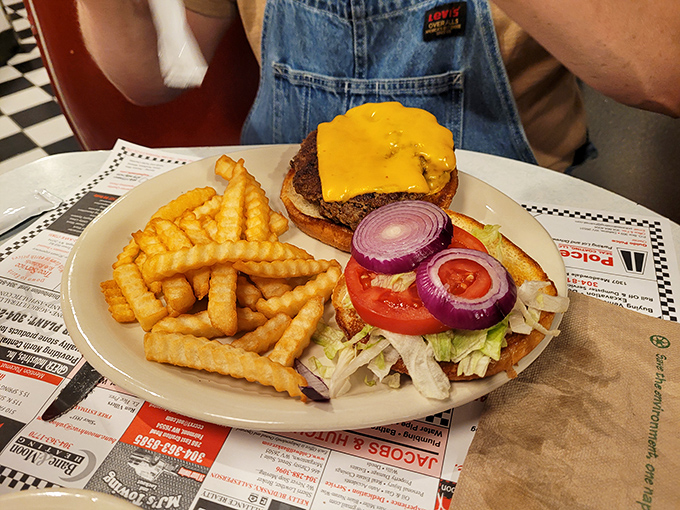 A burger that understands its purpose in life—to deliver perfect beef-to-cheese ratio on a toasted bun with crispy fries standing guard on the side.