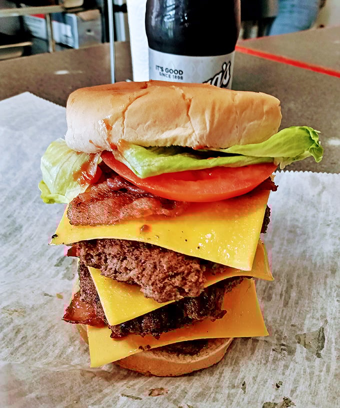This isn't just a burger; it's a skyscraper of flavor that requires both hands, several napkins, and absolutely no shame.