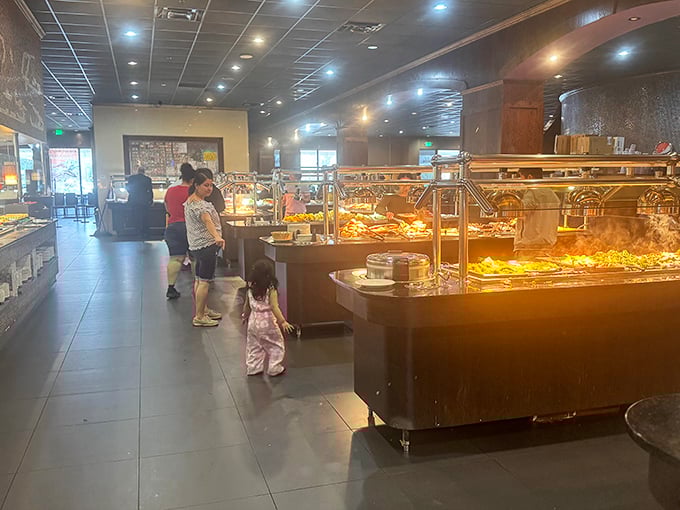 Families navigate the buffet stations with the careful strategy of generals planning battle campaigns – each member assigned to scout different culinary territories.