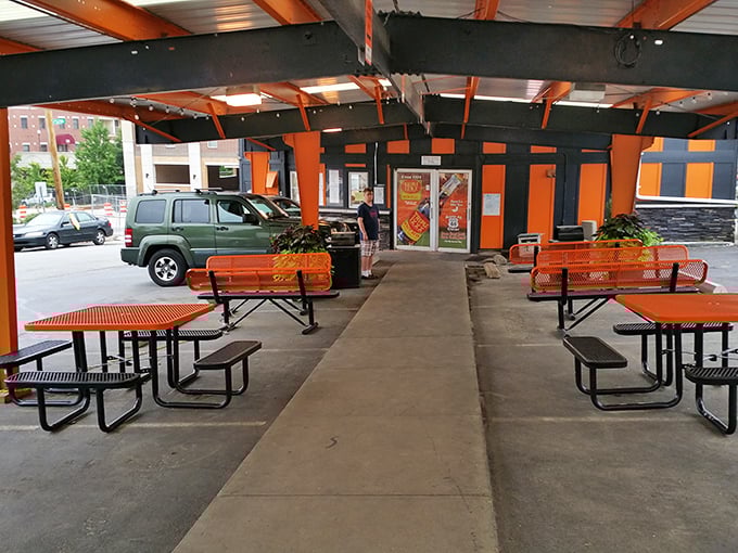 The outdoor seating area carries the signature orange theme, creating a space where fresh air and comfort food form a perfect partnership.