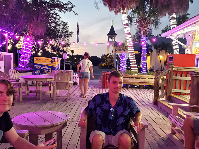 Twilight transforms the porch into a purple-hued dining paradise. These aren't just outdoor tables – they're front-row seats to island magic.