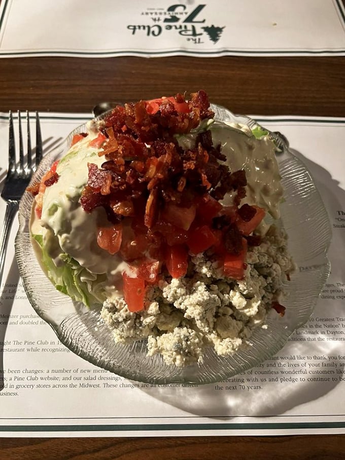 The wedge salad—that steakhouse classic where iceberg lettuce finally gets its moment to shine beneath a blanket of blue cheese and bacon.