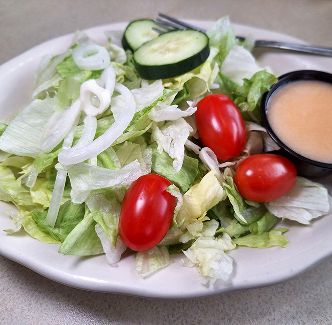 A garden-fresh side salad with crisp vegetables and house dressing—the virtuous prelude that justifies the pie finale that's surely coming.