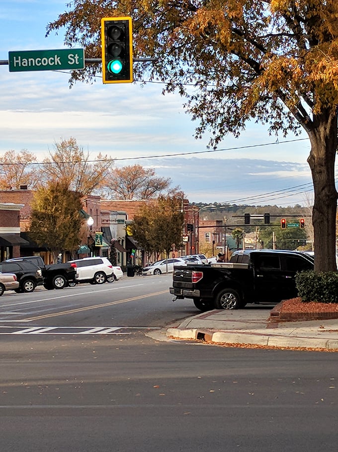 Hancock Street stretches toward the horizon under autumn-tinged trees. In Milledgeville, even traffic lights seem to slow down and enjoy the view.