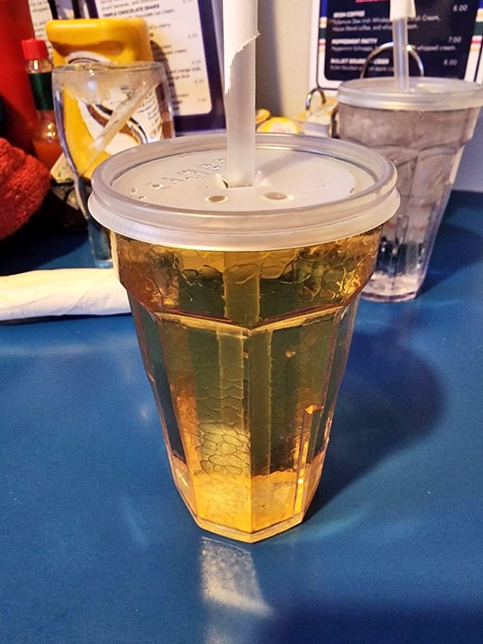 That's not just apple juice—it's liquid sunshine in a crackle glass, ready to wash down whatever comfort food you've wisely ordered.