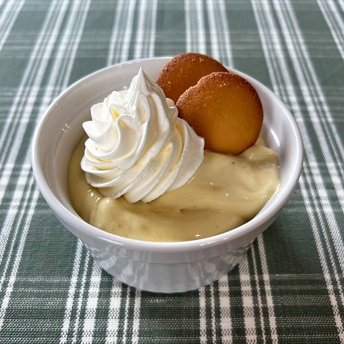 Banana pudding crowned with a cloud of whipped cream and vanilla wafers. The kind of dessert that makes you consider licking the bowl in public.