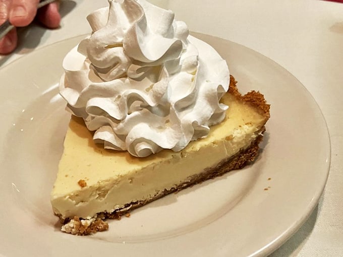 The cheesecake that ends all cheesecake debates—topped with whipped cream clouds of pure joy.