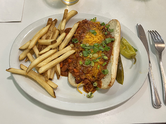The chili dog arrives like it's auditioning for a food commercial – cheese melting into spicy chili, green onions adding color, and fries standing at attention.
