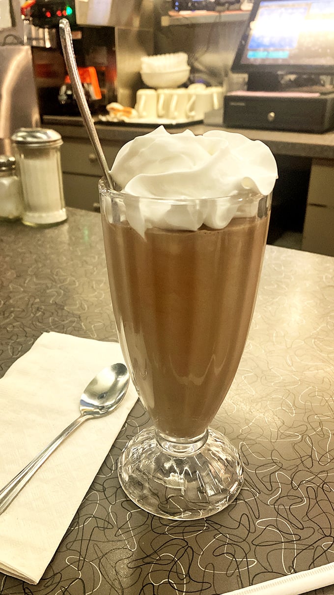 A chocolate milkshake topped with a cloud of whipped cream – the kind that makes you wish straws were wider and afternoons were longer.