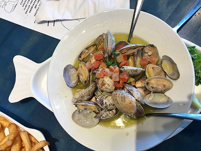 Steamed clams swimming in garlicky broth with fresh tomatoes—proof that sometimes the simplest preparations deliver the most profound seafood joy.